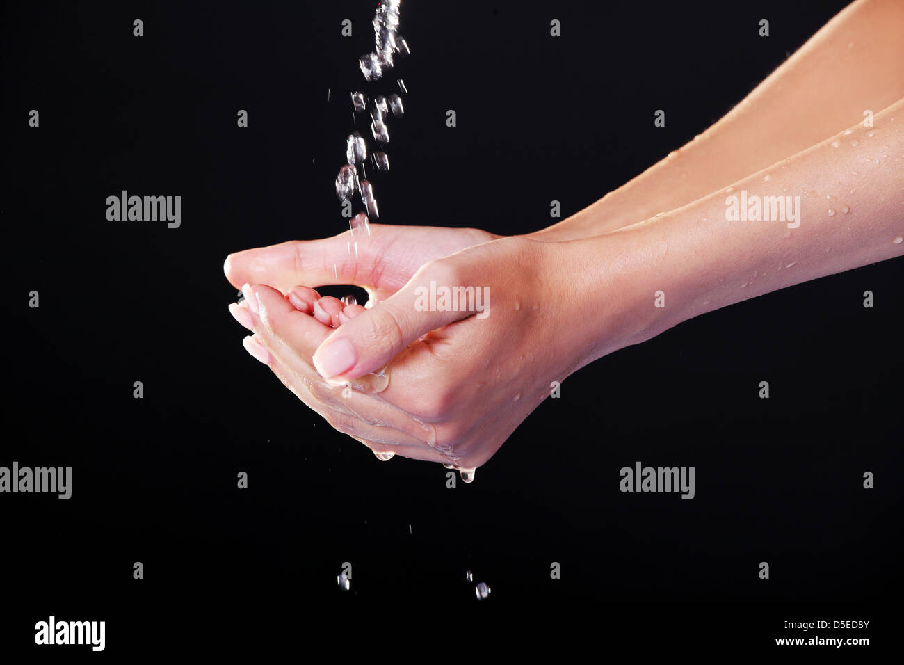 Water falling on female hands, over black background Stock Photo - Alamy