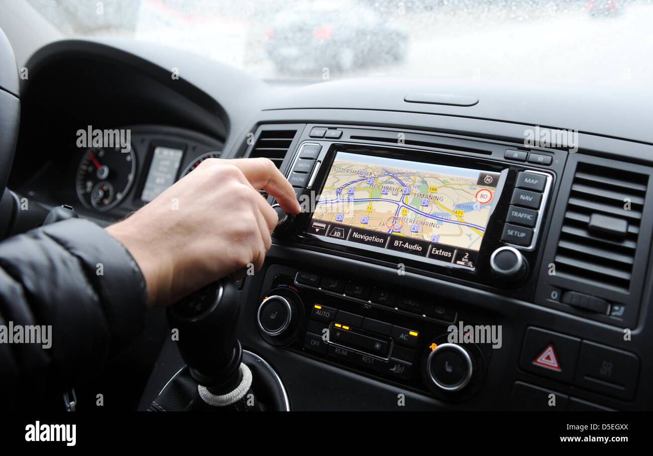 A man operates his navigation system while driving in his car in Munich ...