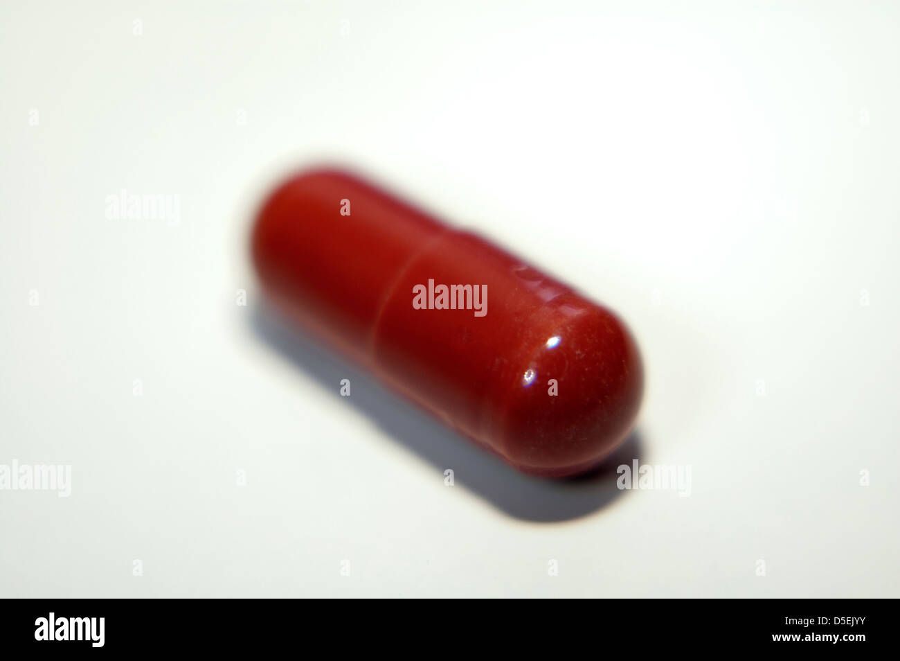 Red pill on white background Stock Photo - Alamy