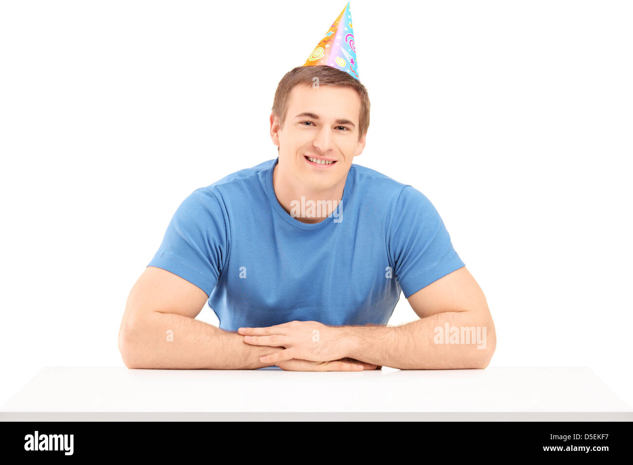 A smiling birthday guy with a party hat posing isolated on white ...