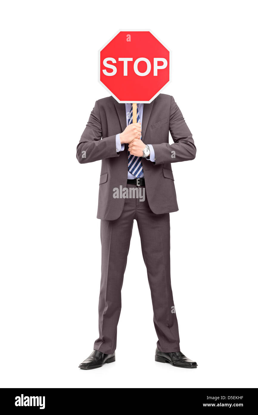 Full length portrait of a man in suit covering his face with a stop ...