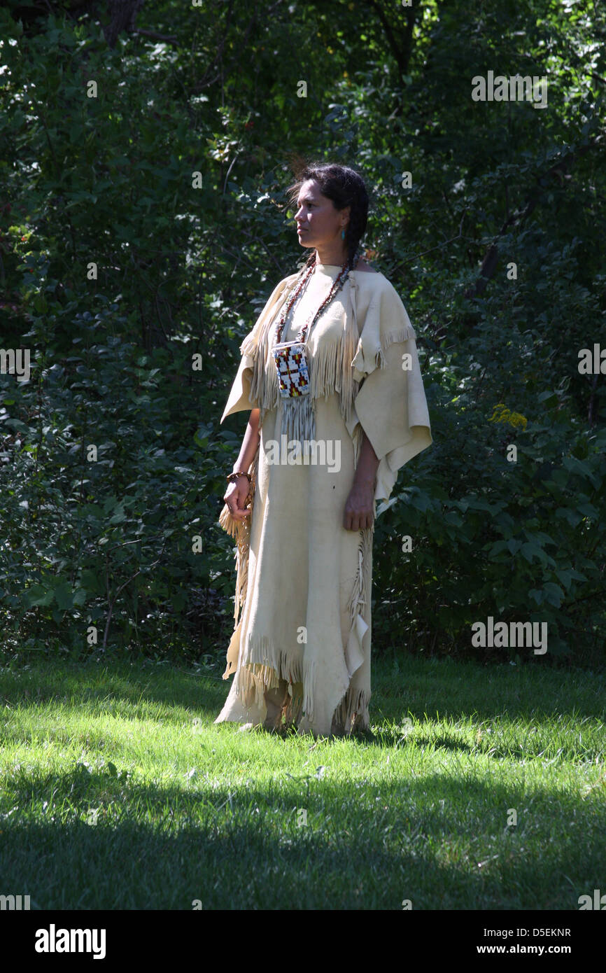 A Native American Indian Lakota Sioux woman standing in a leather dress ...