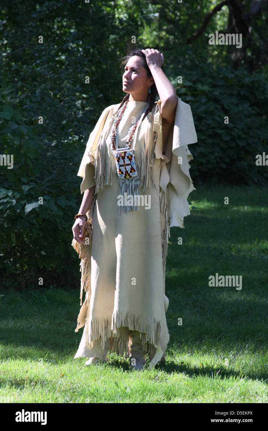 A Native American Indian Lakota Sioux woman standing in a leather dress ...