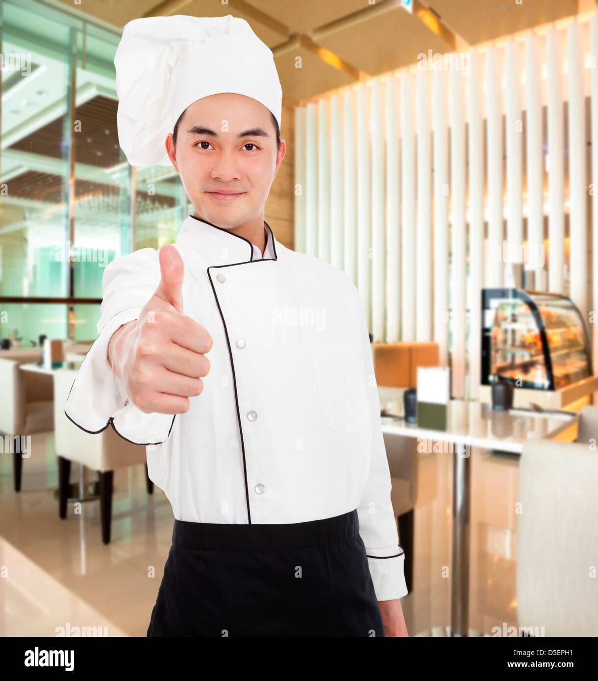 young chef with thumb up gesture in the restaurant Stock Photo - Alamy