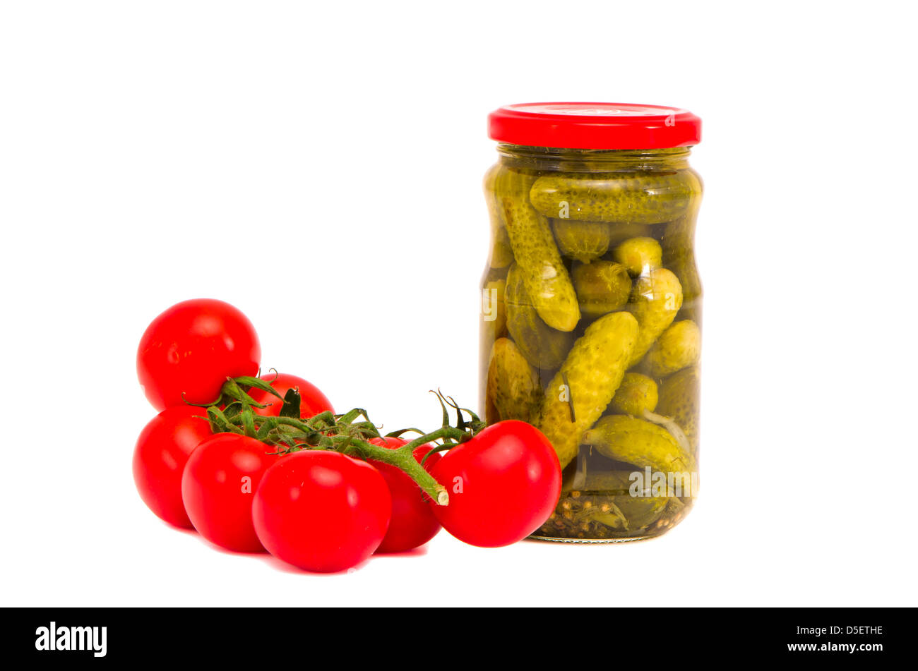 preserved cucumbers jar and fresh tomato bunch isolated on white Stock ...
