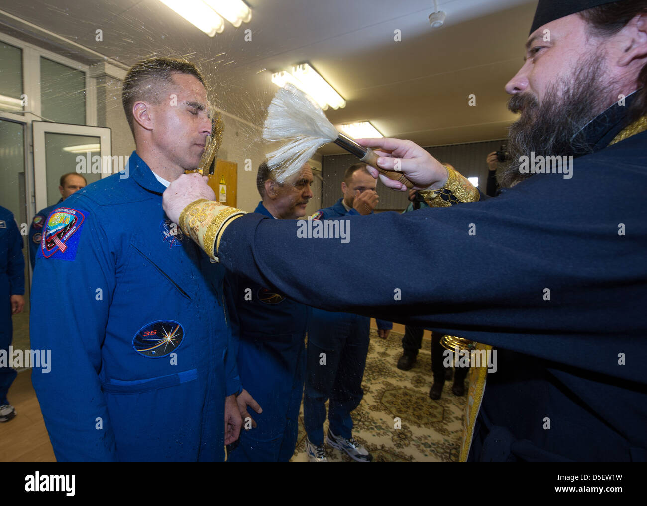 Expedition 35 NASA Flight Engineer Chris Cassidy, left, receives the ...