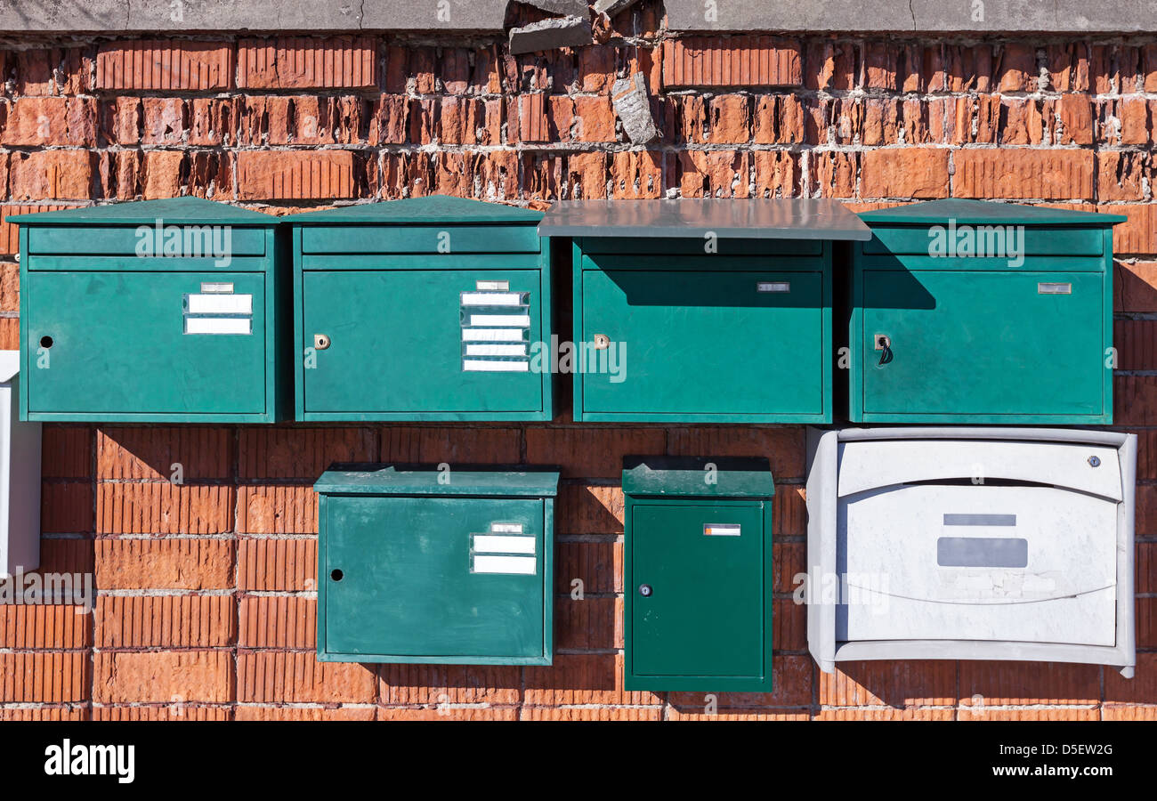 Green European metal post boxes on old brick wall Stock Photo - Alamy