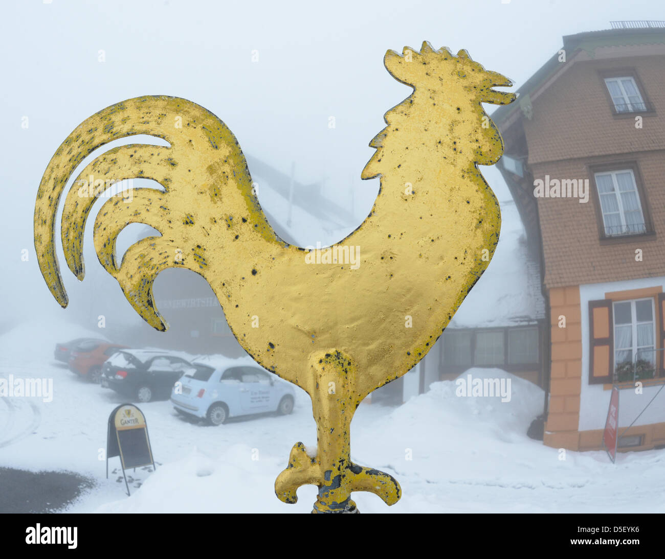 Weathercock stands in front of a snow covered house near St. Maergen in ...