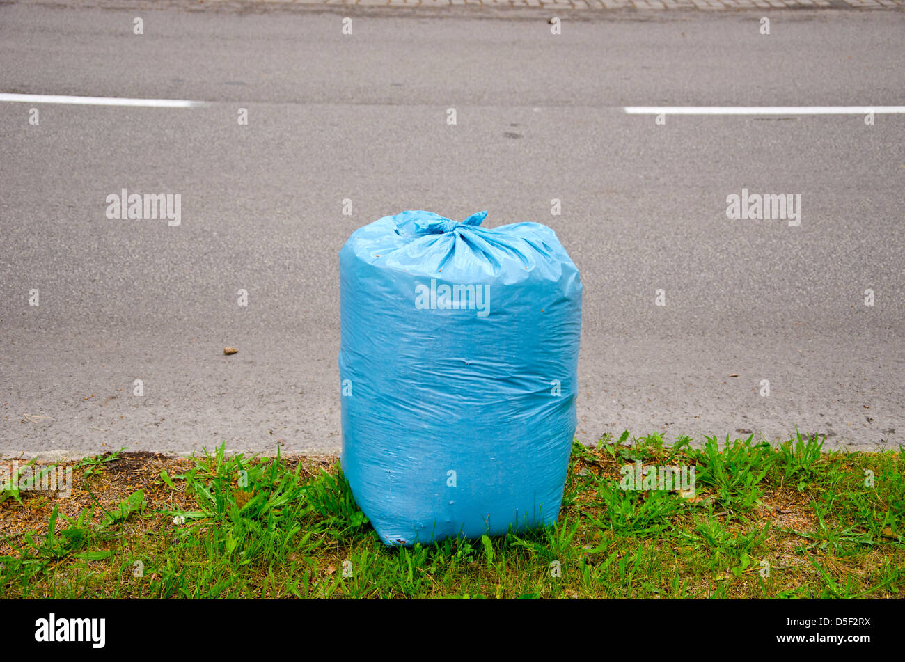 blue garbage plastic bag on city street Stock Photo - Alamy