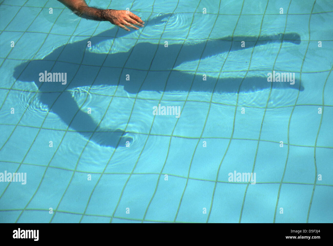 Man floating on his back casts a shadow in a pool Stock Photo - Alamy