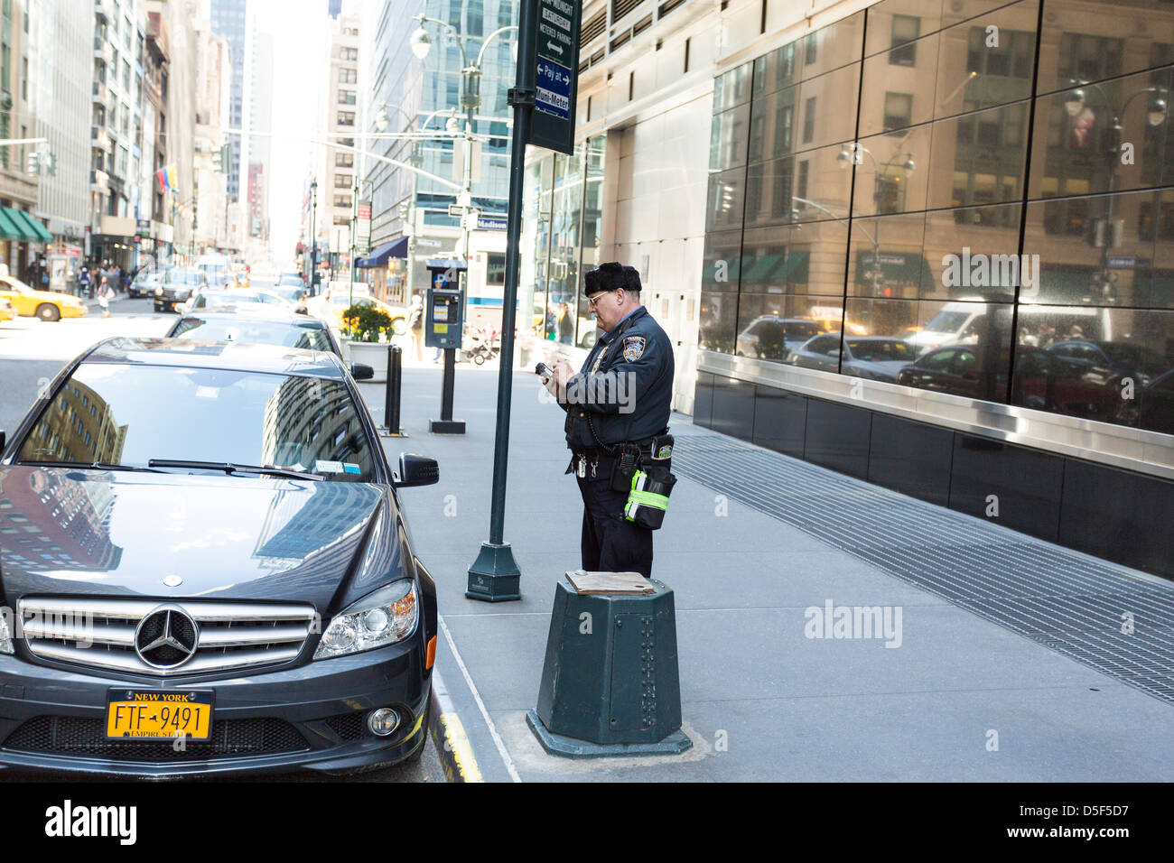 Police officer writing a ticket for incorrect parking in New York City ...