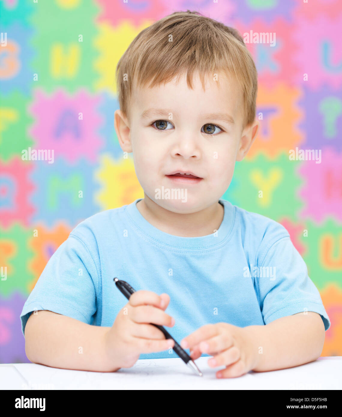 Little boy is writing on his copybook in preschool Stock Photo - Alamy