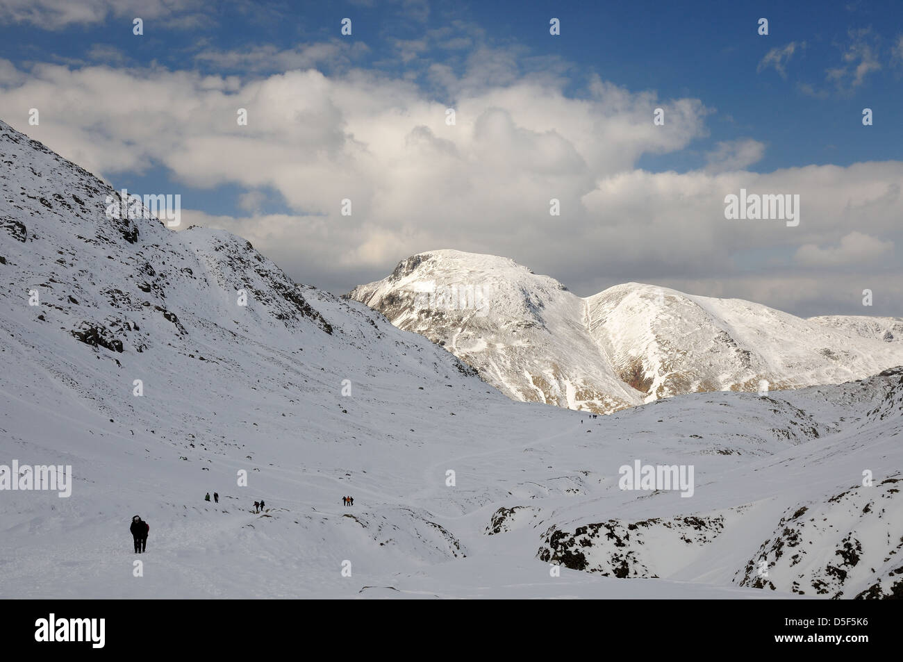 Walkers approaching Esk Hause in winter in the English lake District ...