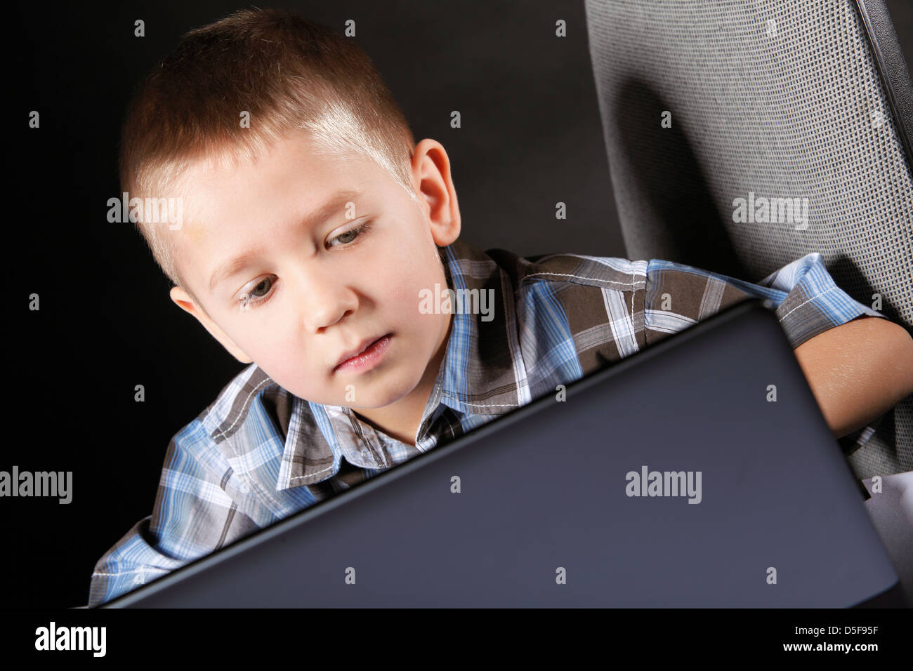 Computer addiction child boy with laptop notebook black background ...
