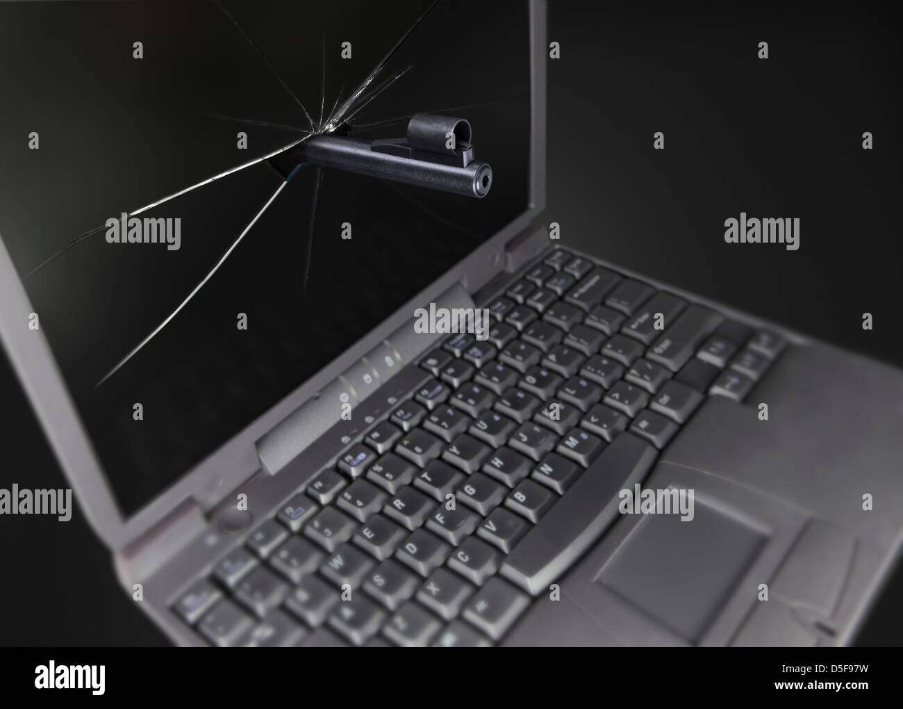 the gun breaks the laptop screen and passes through it. Low key, side ...
