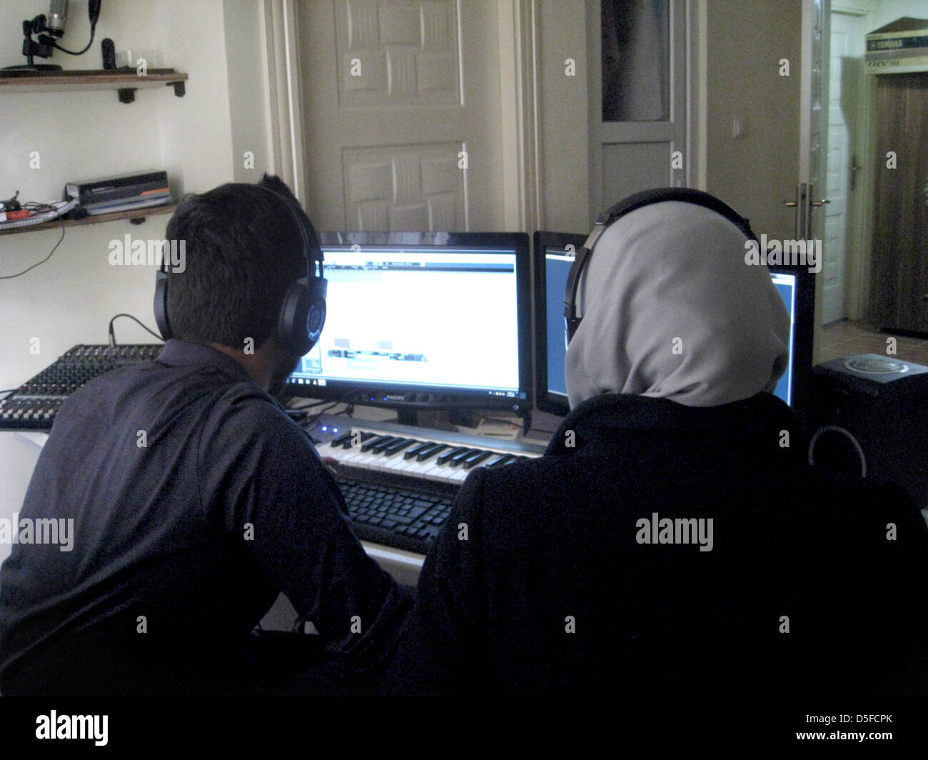 two members of the Syrian underground radio station 'Radio Brise' sit ...