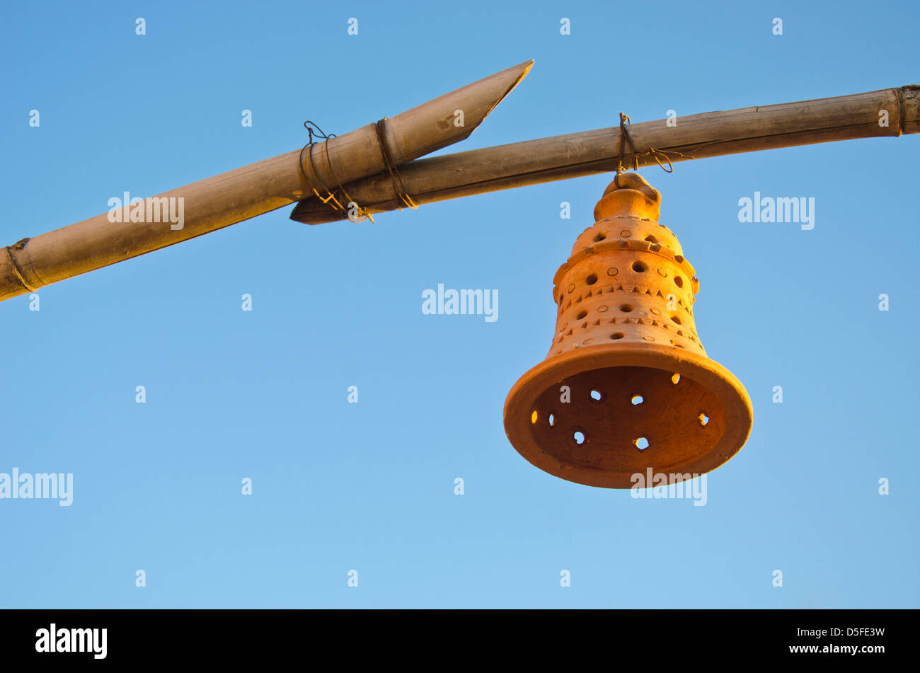bell form decorative clay lamp on bamboo in India Stock Photo - Alamy