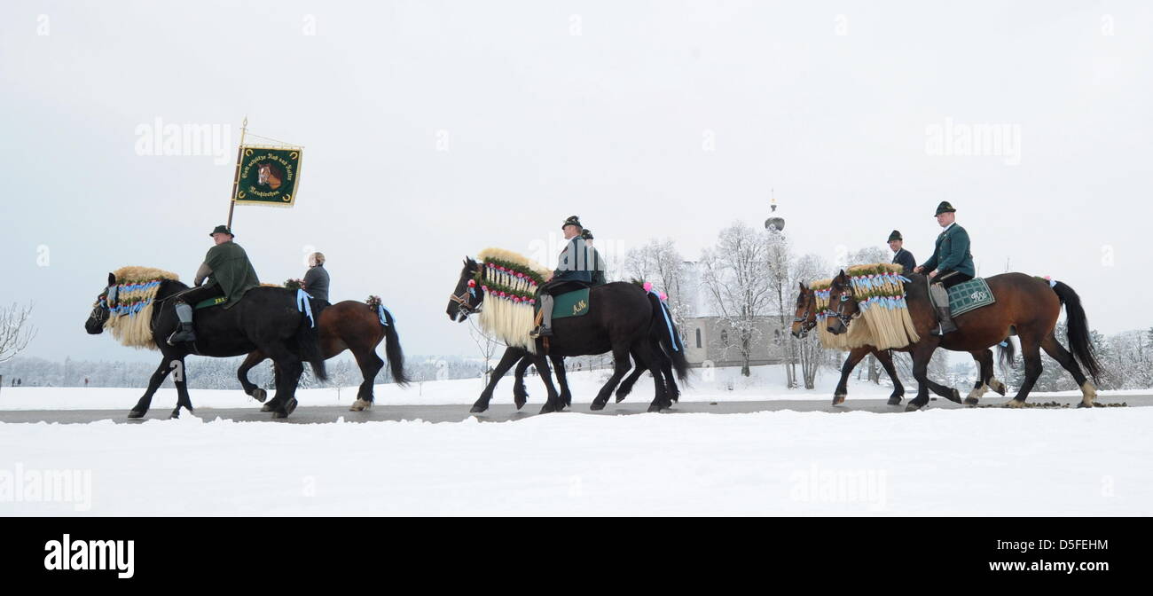 Men wearing German traditional costumes ride on their decorated horses ...