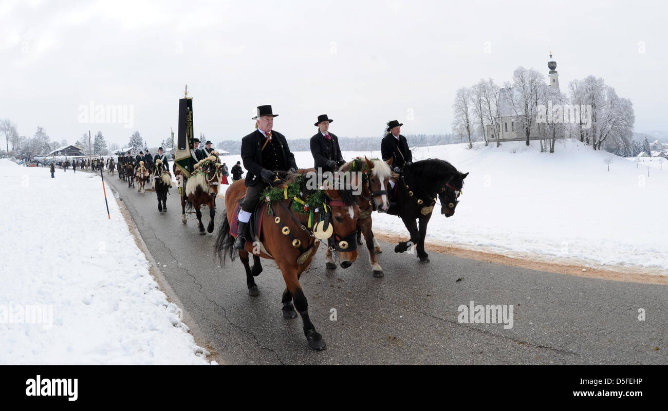 Men wearing German traditional costumes ride on their decorated horses ...
