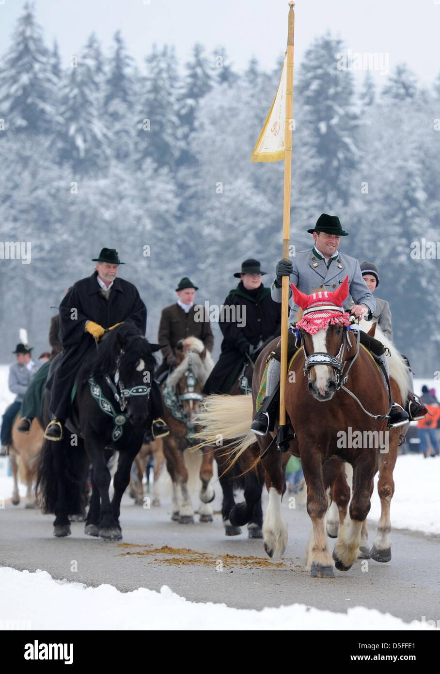 Men wearing German traditional costumes ride on their decorated horses ...