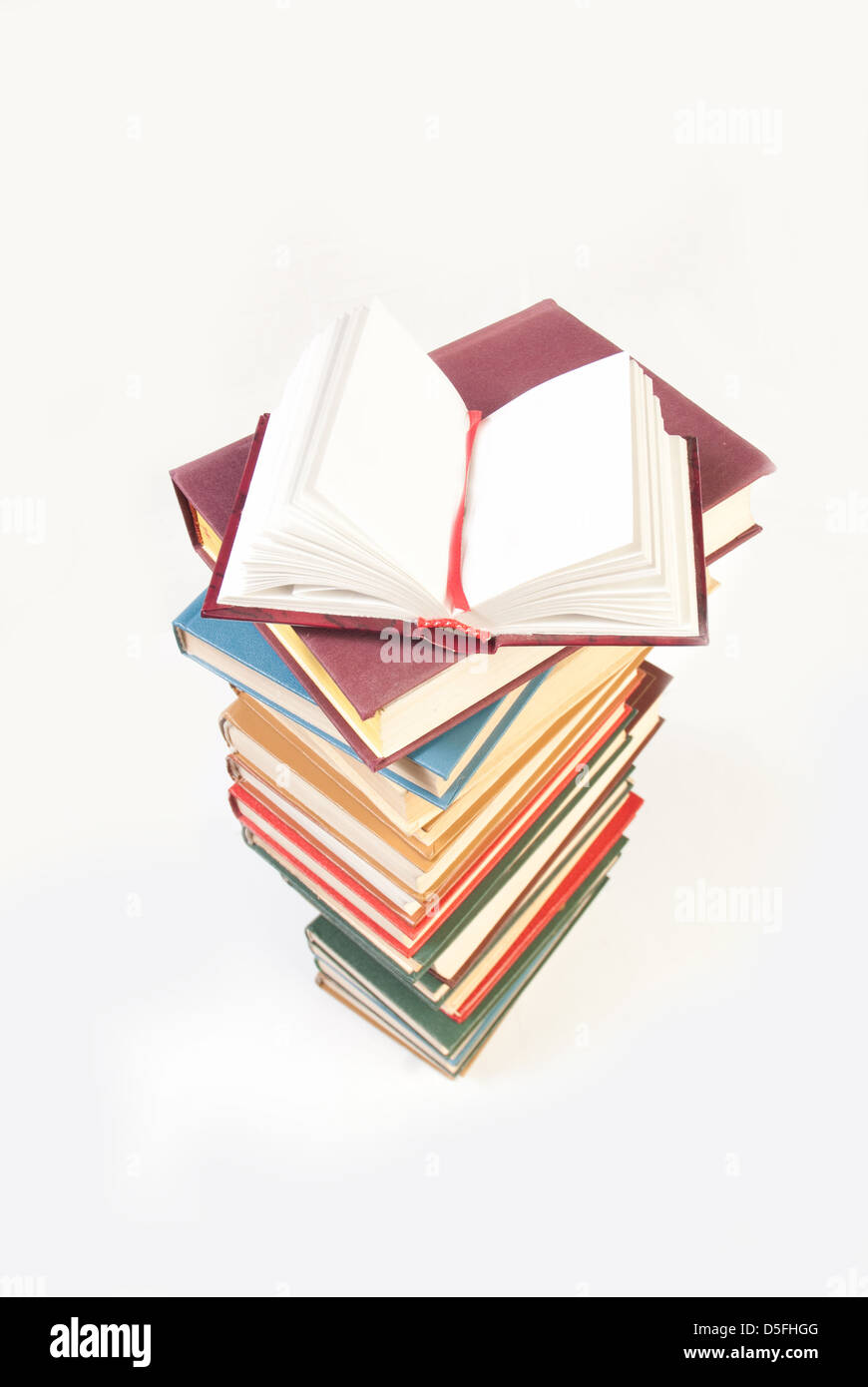 pile of books with one book open on white background Stock Photo - Alamy