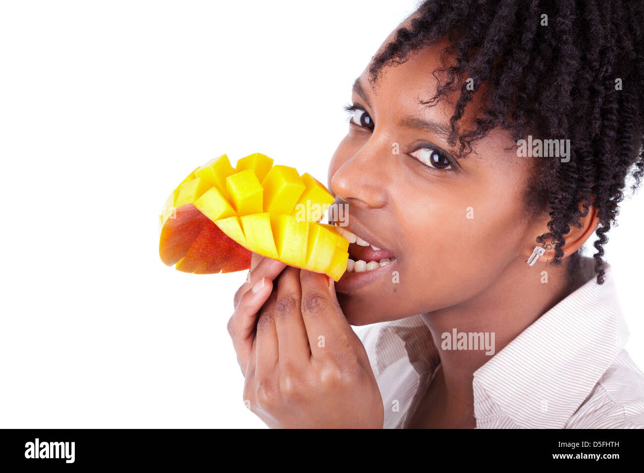 Young happy black / african american woman eating fresh mango isolated ...