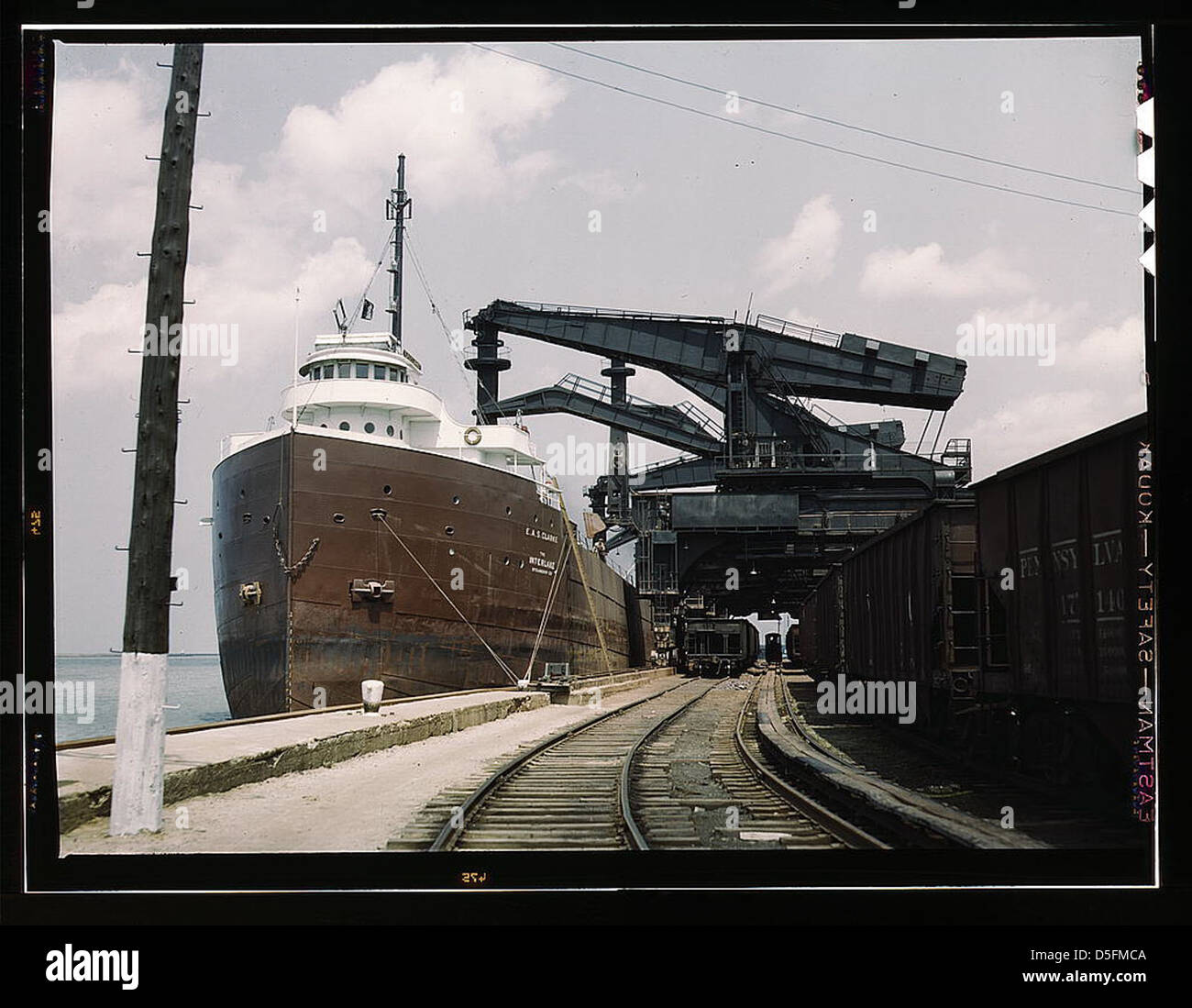 A photograph depicting the unloading of ore from a lake freighter at ...