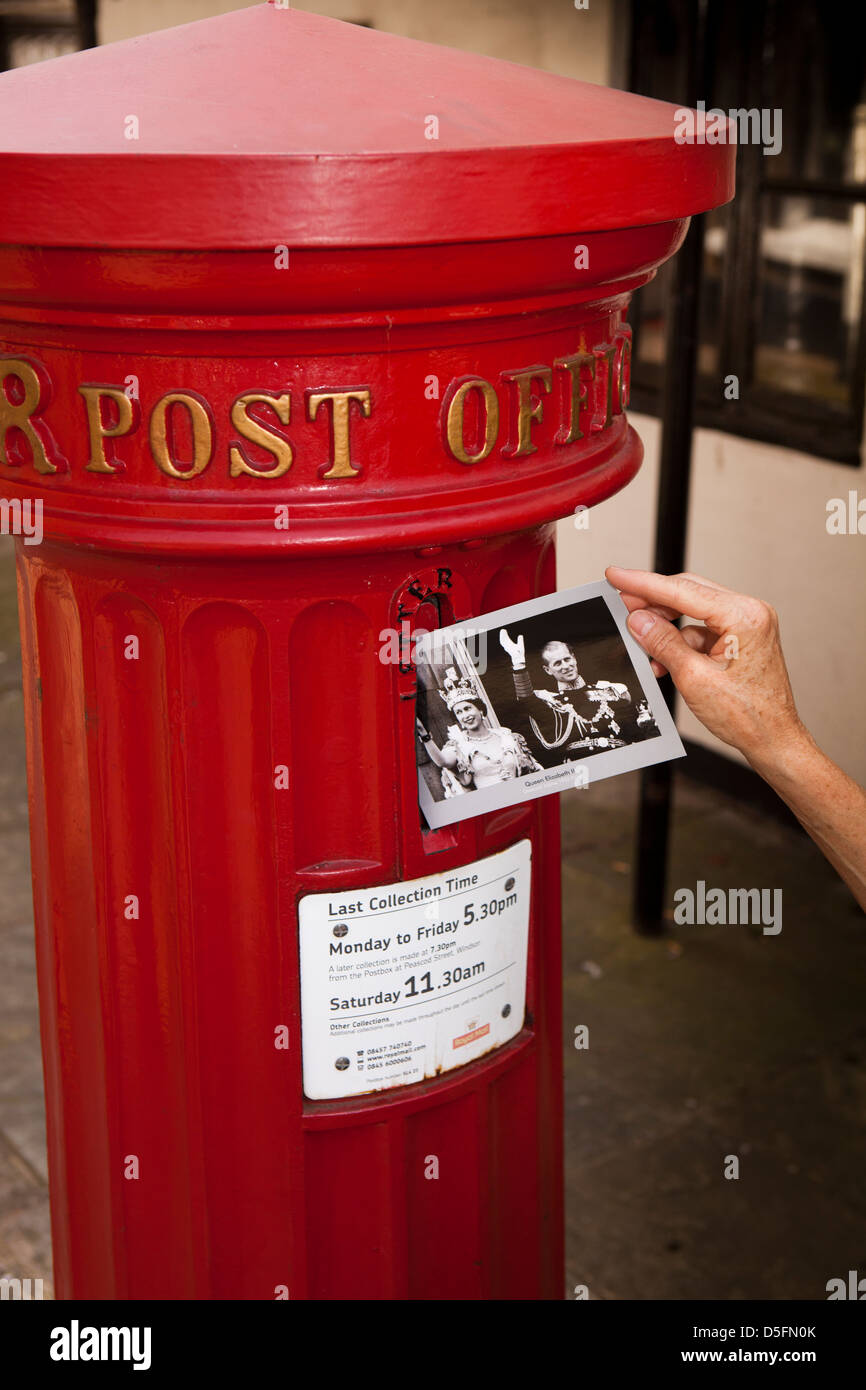 England, Berkshire, Eton High Street, posting Royal family postcard in ...