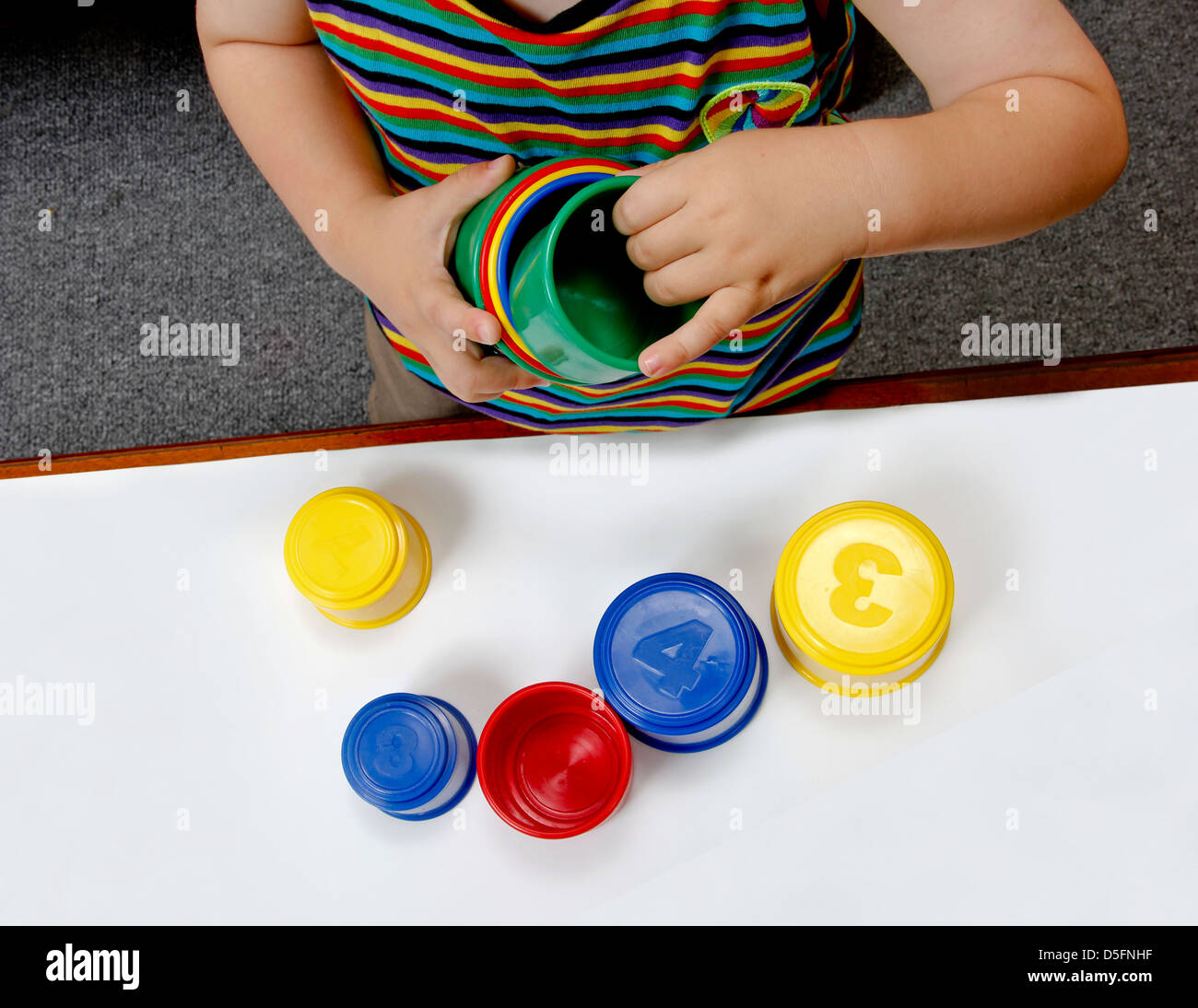 Baby playing with plastic cups educational Stock Photo - Alamy