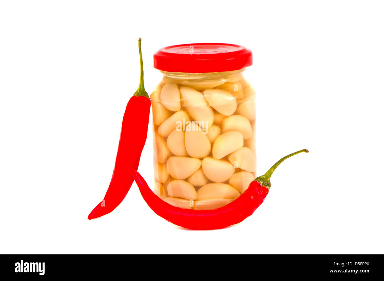 potted garlic in glass jar and two red hot chili peppers isolated on ...