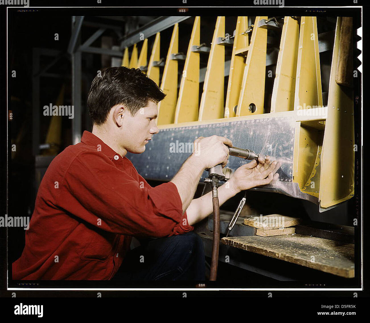 A photograph from October 1942 showing a male riveter working on an ...