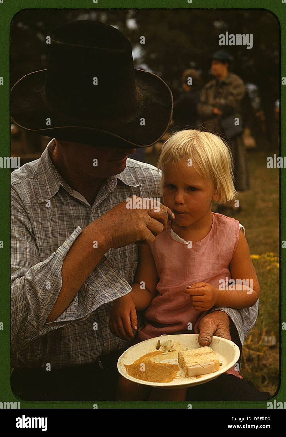 A 1940s photograph showing a homesteader feeding his daughter at the ...