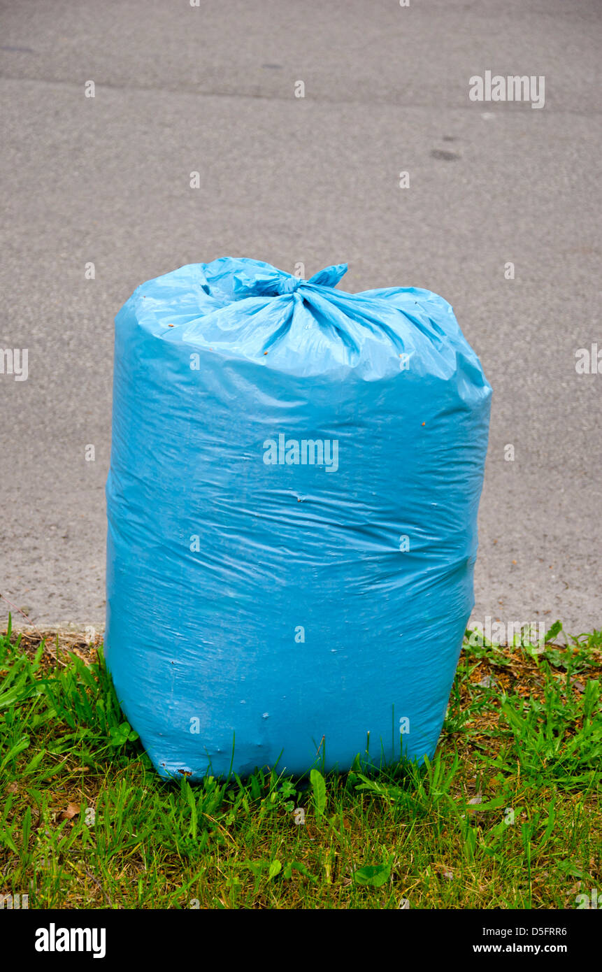 blue plastic garbage bag on city street Stock Photo - Alamy