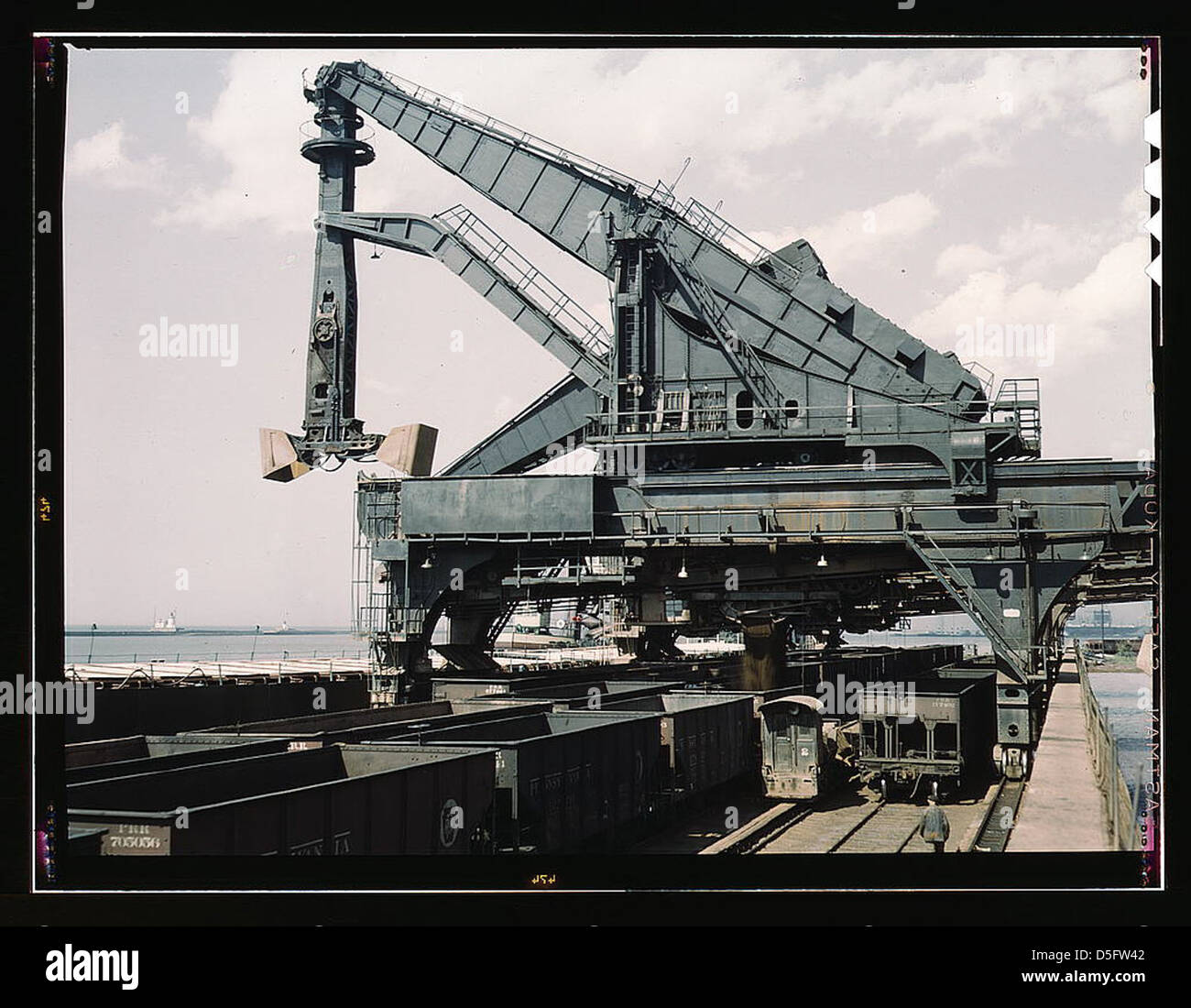 The photo shows the unloading of iron ore from a lake freighter at the ...