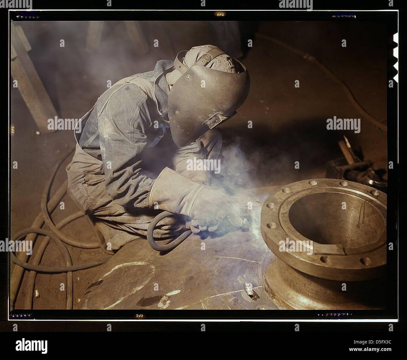 A photograph taken in June 1942 shows a welder at the Combustion ...
