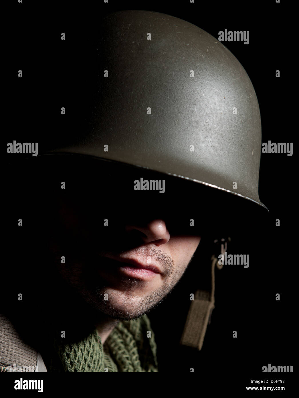 Portrait of a WW2 U.S. soldier in deep shadow against a black ...
