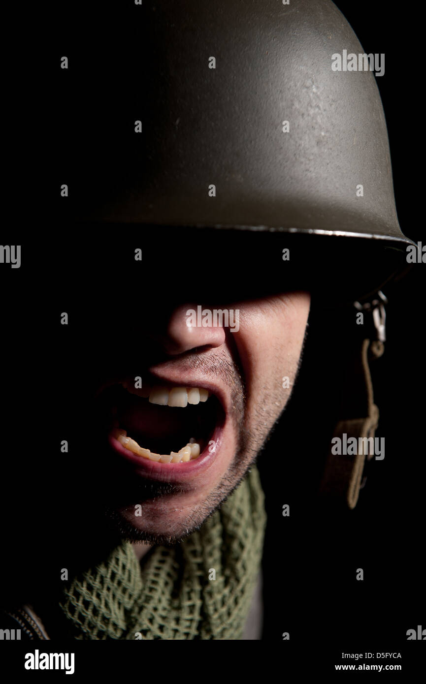 Portrait of a WW2 U.S. soldier shouting, with deep shadows against a ...