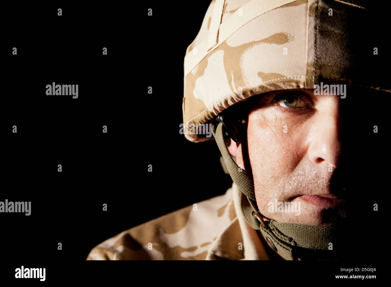 Close up portrait of a British soldier. The soldier is spotlit creating ...