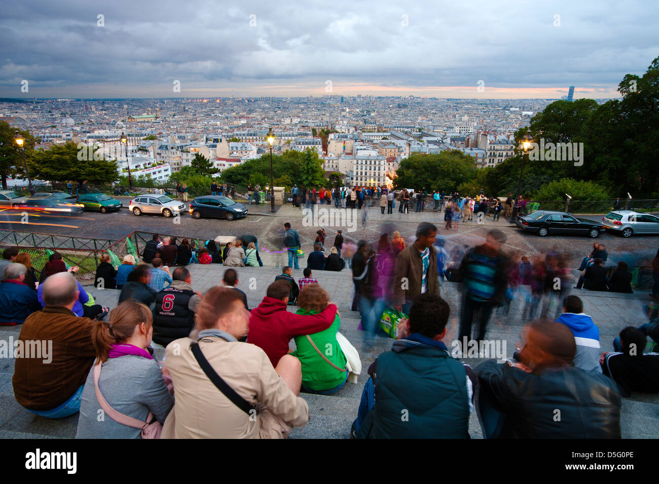 people on stairs of Sacré-Coeur Basilica enjoy the view of Montmartre ...