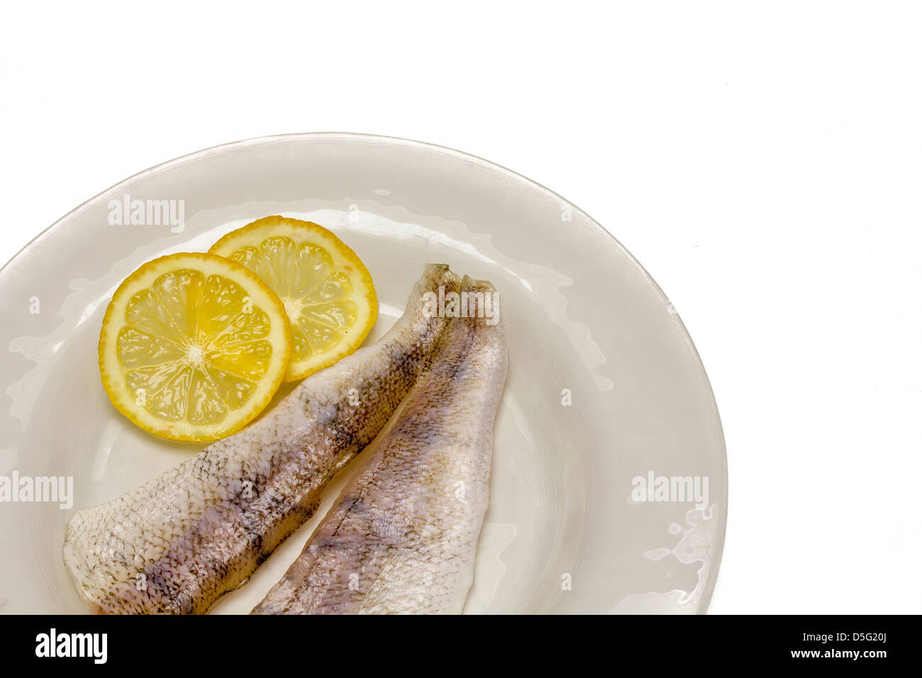 Raw fish fillets with lemon slices in white plate Stock Photo - Alamy