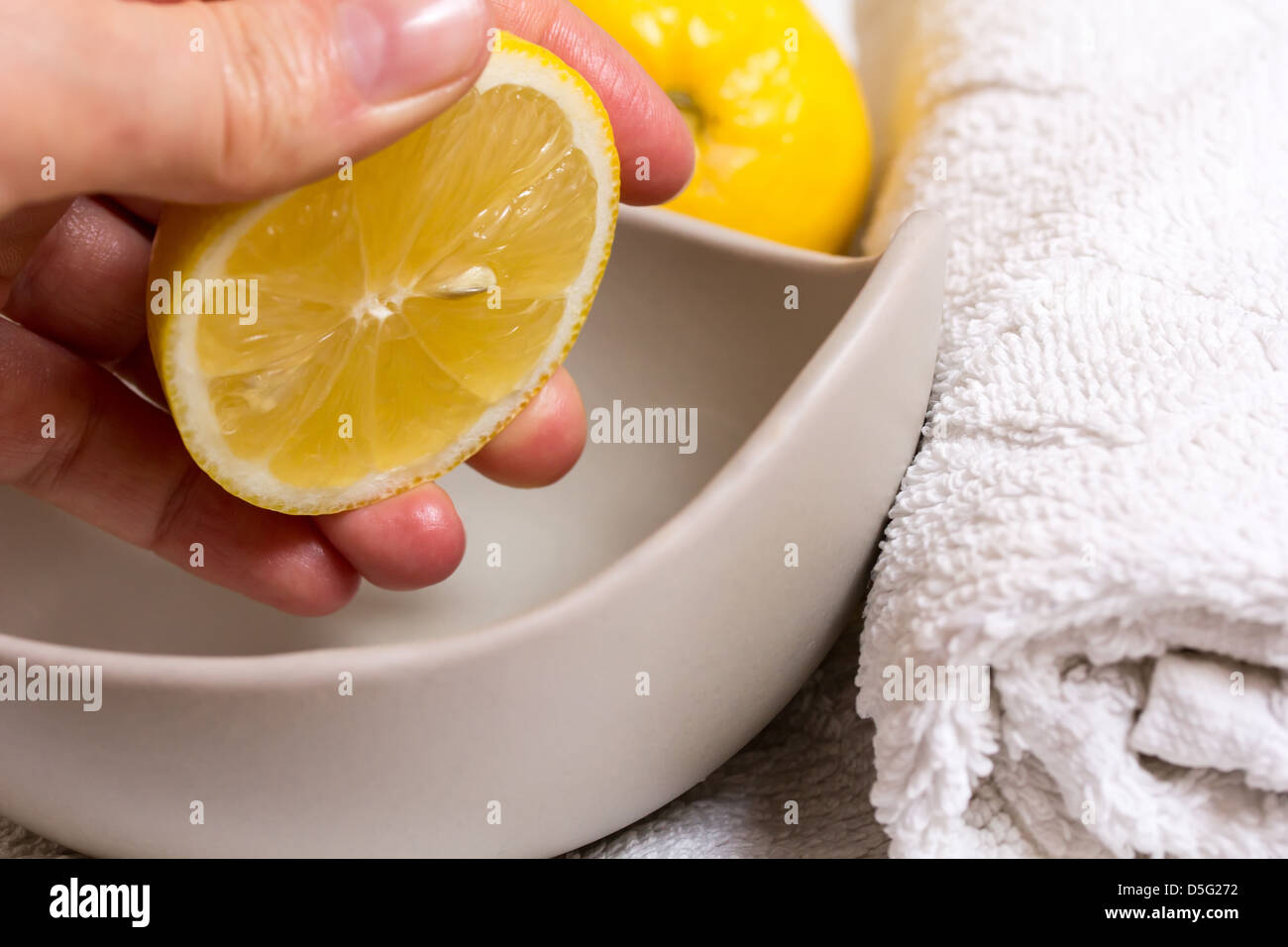 Pressed lemon in wellness by a woman hand Stock Photo - Alamy