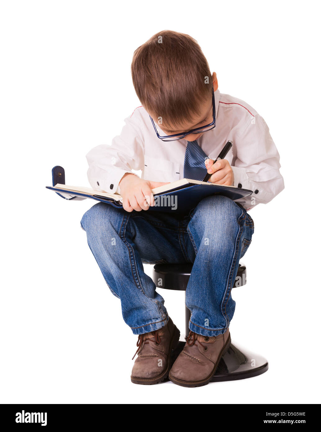 Small concentrated kid write down in organizer notebook with pen ...