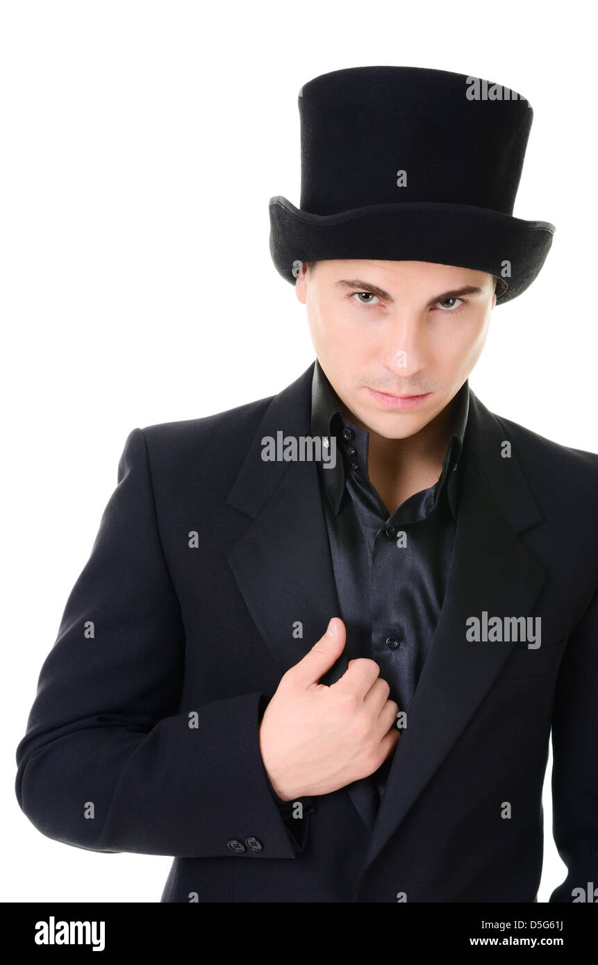 Serious strict man illusionist in black suit and high top hat isolated ...