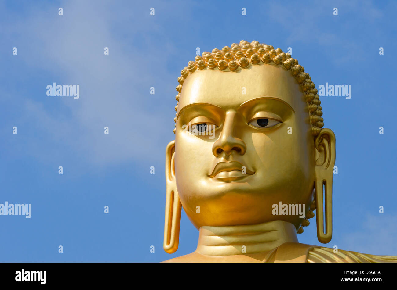 Golden yellow Buddha statue head on blue sky background Stock Photo - Alamy
