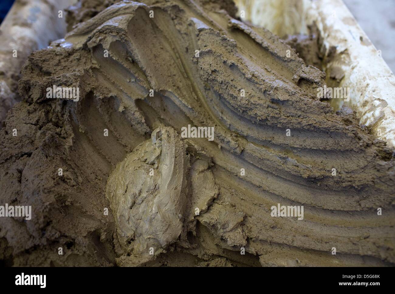 A clay mixture for clay bricks lies in an old bathtub at the brick ...