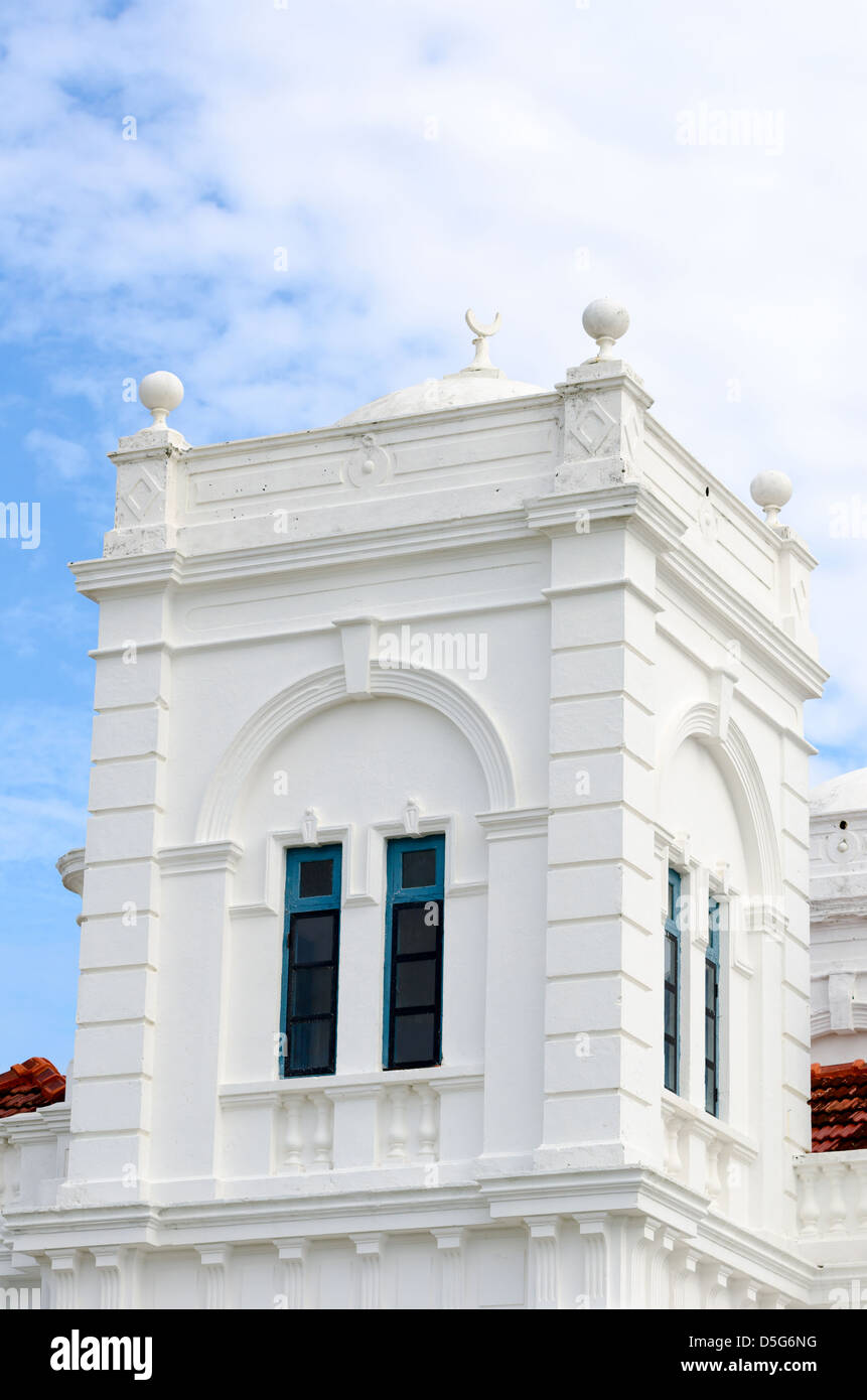White mosque tower with muslim Crescent on the top with cloudy sky on ...