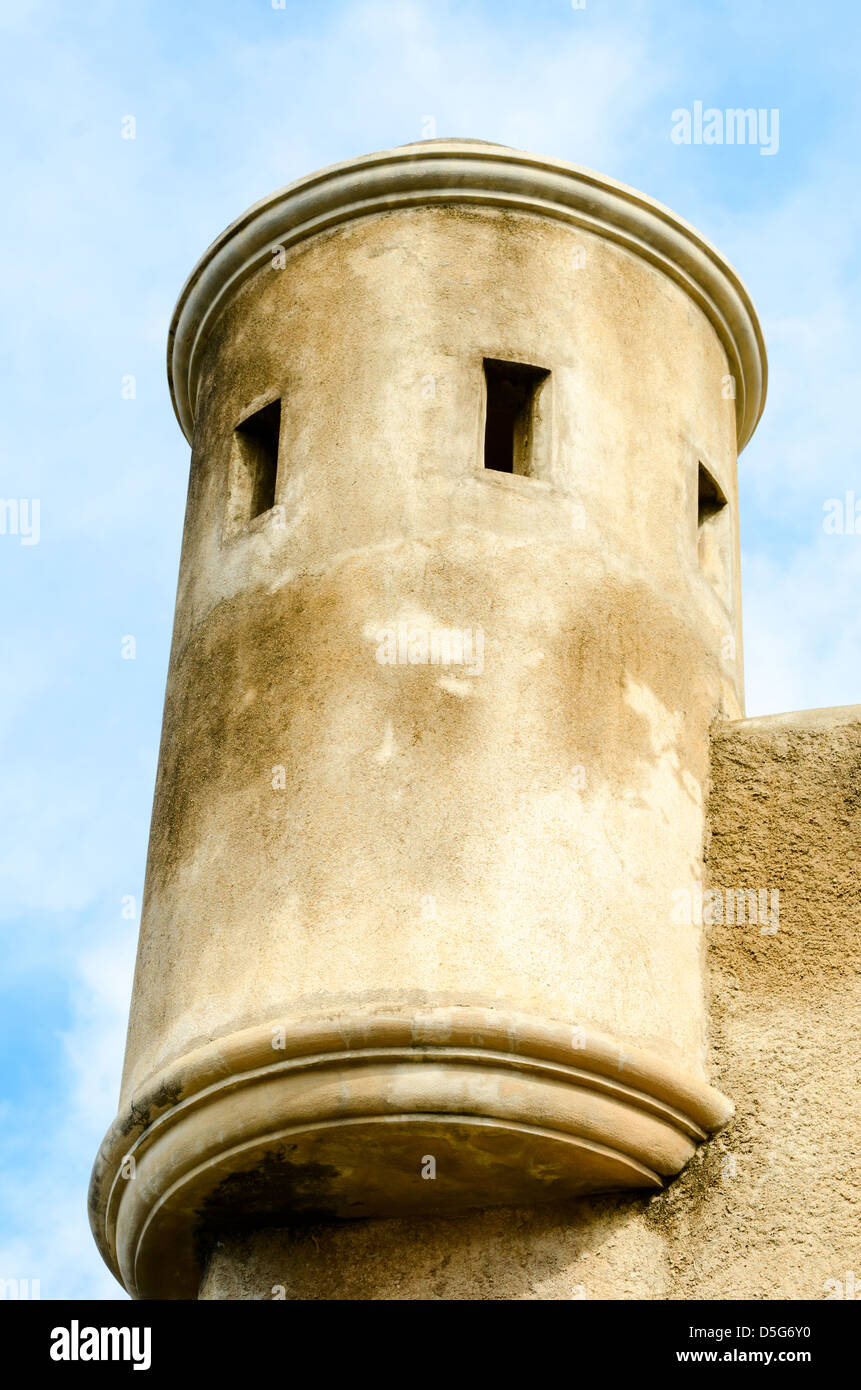 Old military tower with gun slots above fort wall with cloudy ...