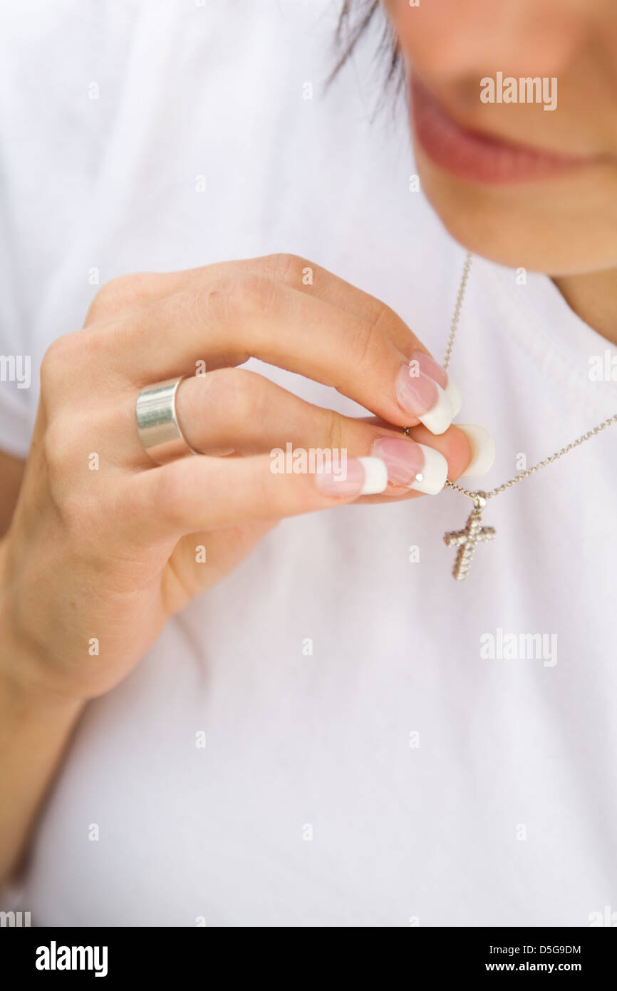 Young woman holding cross necklace in her hand Stock Photo - Alamy