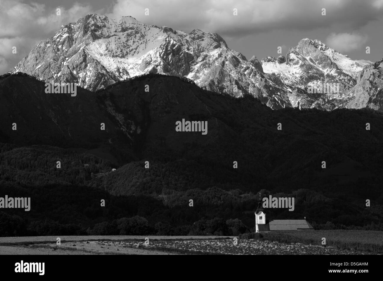 Mountaintops of the Kamnik Alps with the church of Saint Peter sitting ...