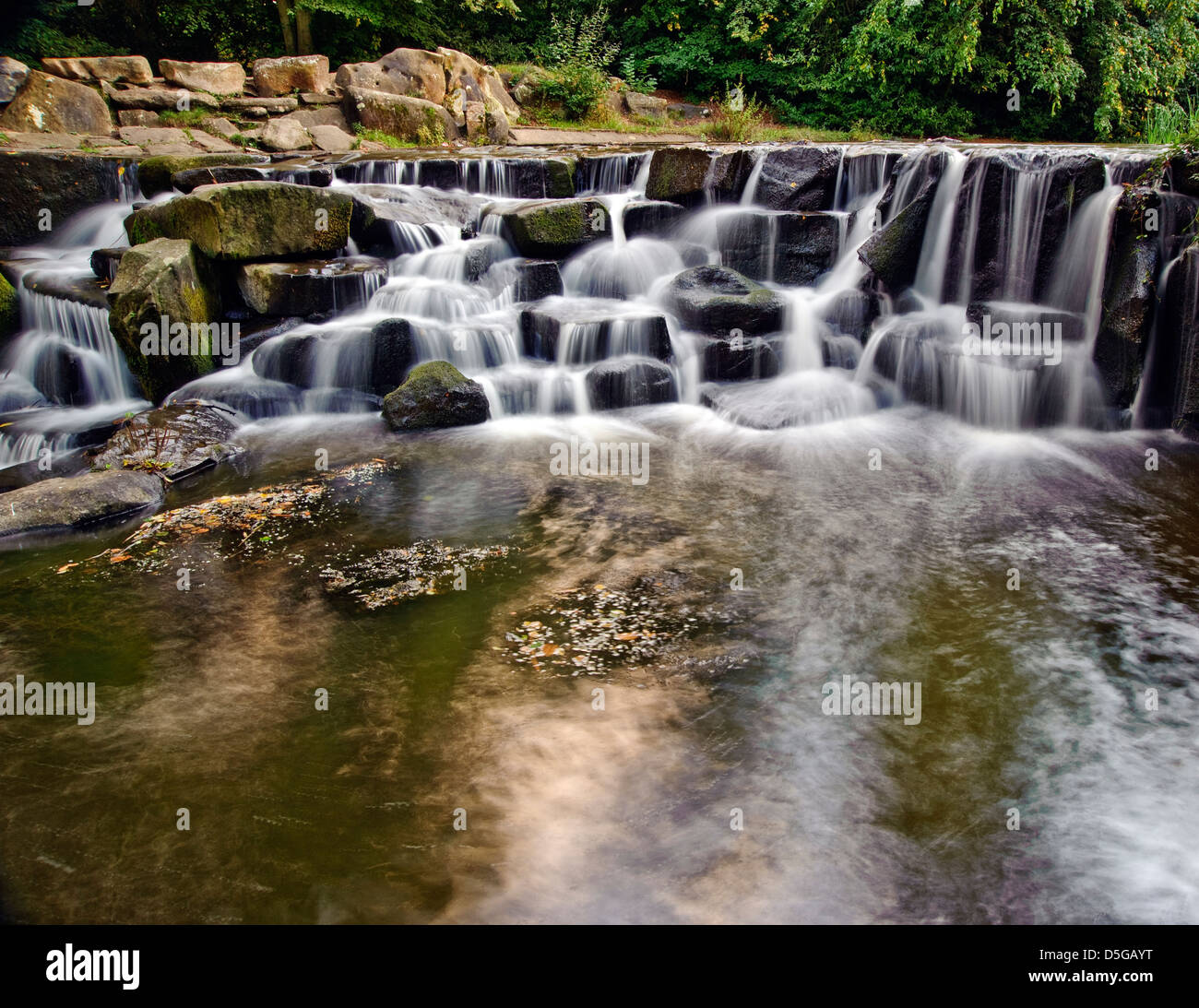 Waterfall cascades flowing over flat rocks in forest landscape Stock ...
